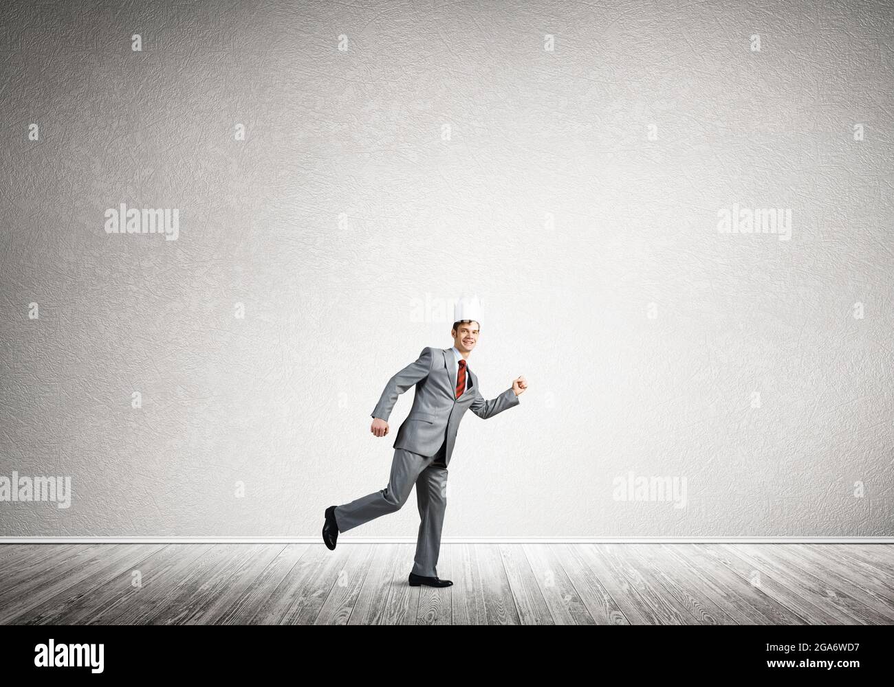 King businessman in elegant suit running in empty room Stock Photo - Alamy