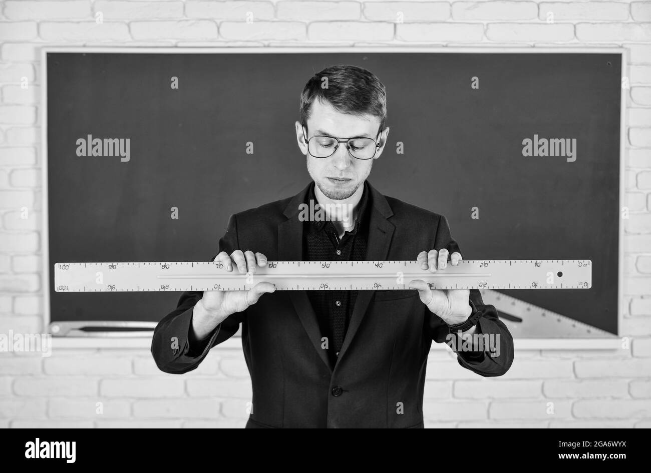 Teacher man at chalkboard holding ruler, math subject concept Stock ...