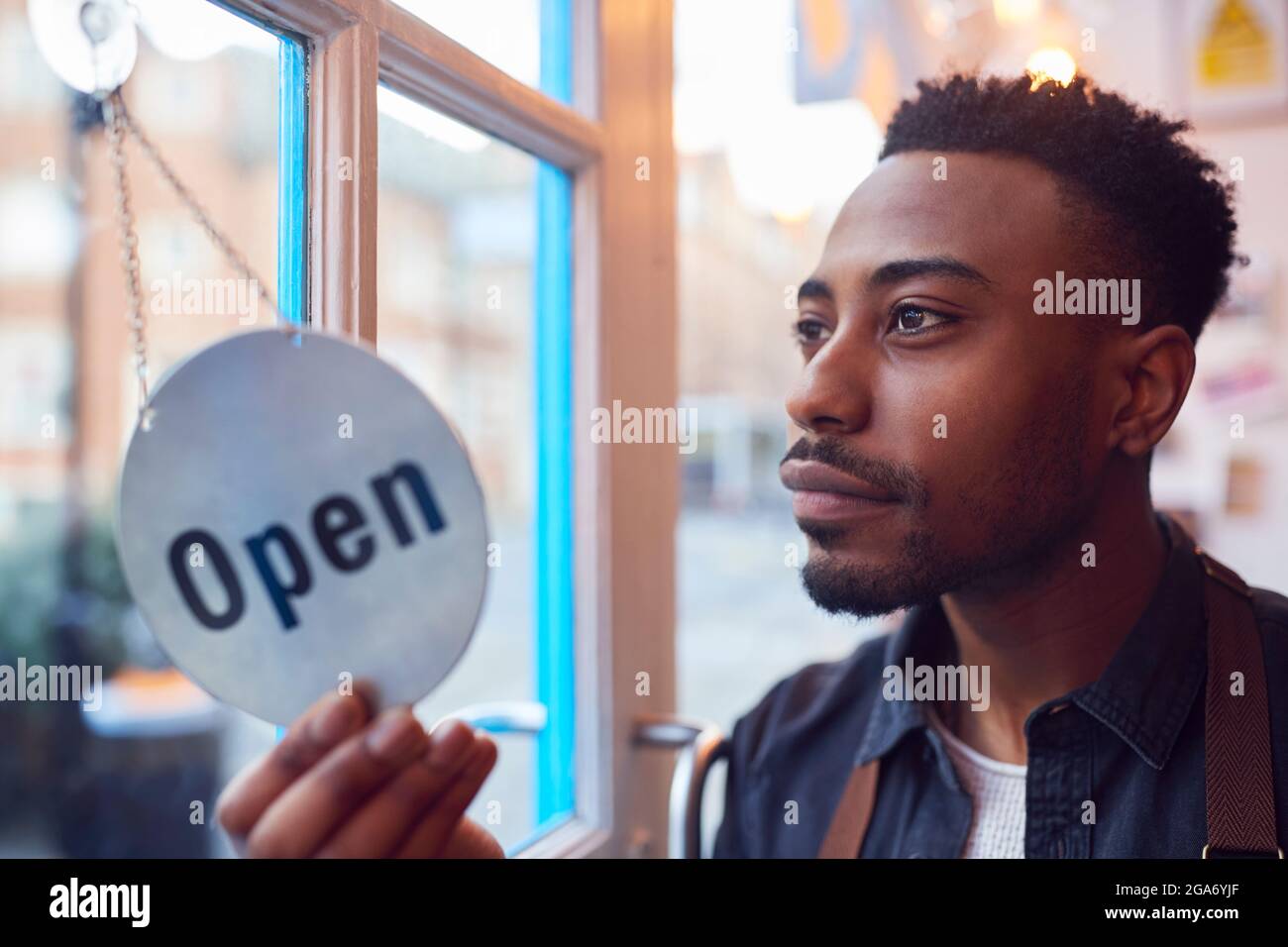Man turning close sign to open sign hi-res stock photography and images ...