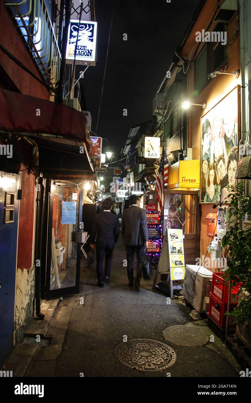 Salarymen in suits walk through the Golden Gai neighborhood of Shinjuku ...