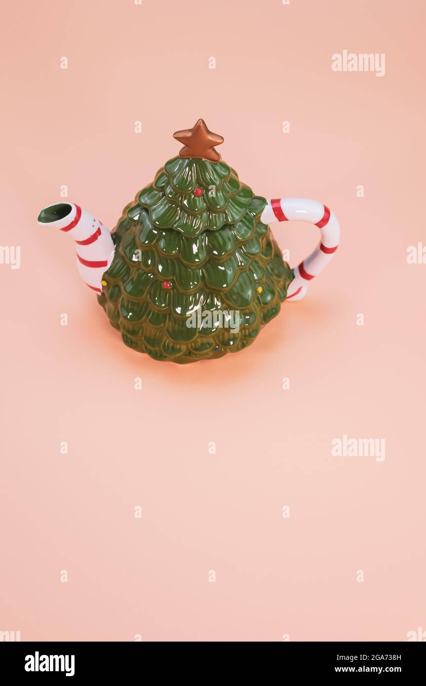 Vertical shot of a kettle in the shape of a Christmas tree on a coral ...