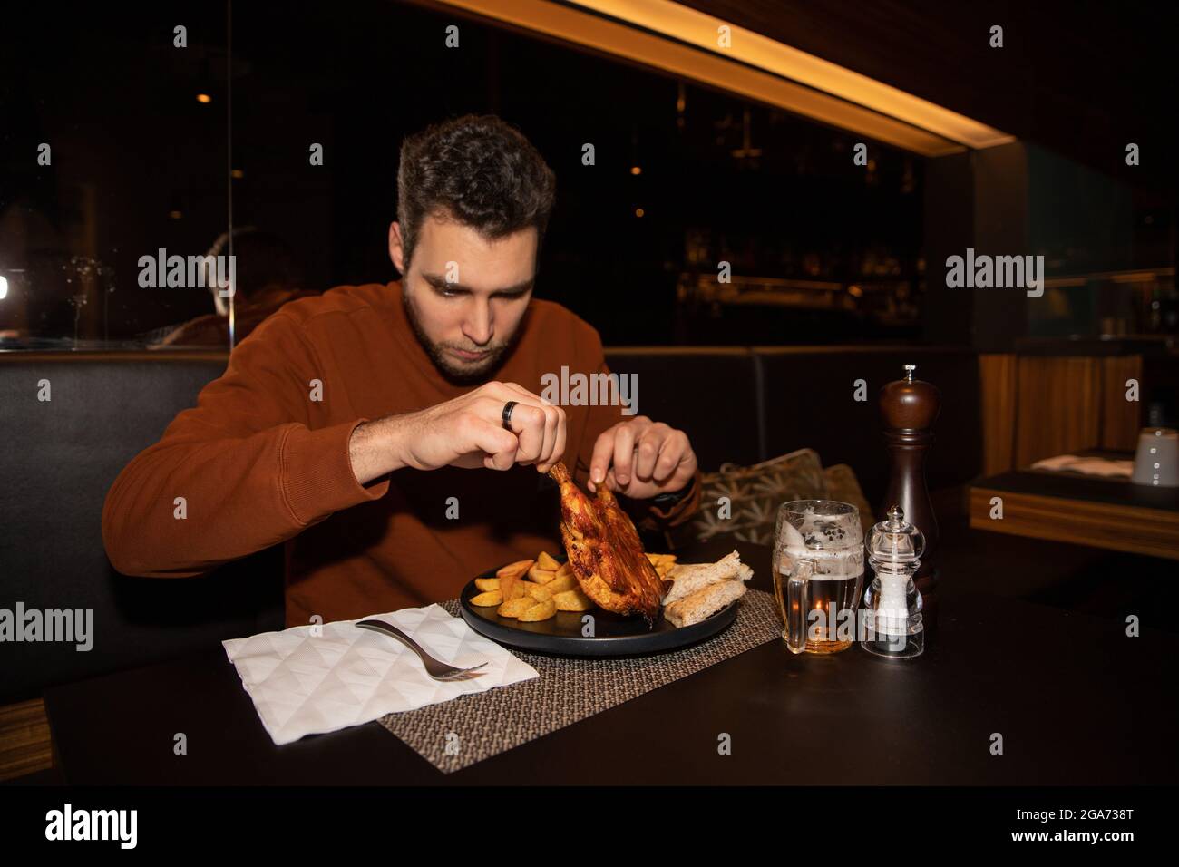 a restaurant customer eats his food, some chicken and fries and a beer ...