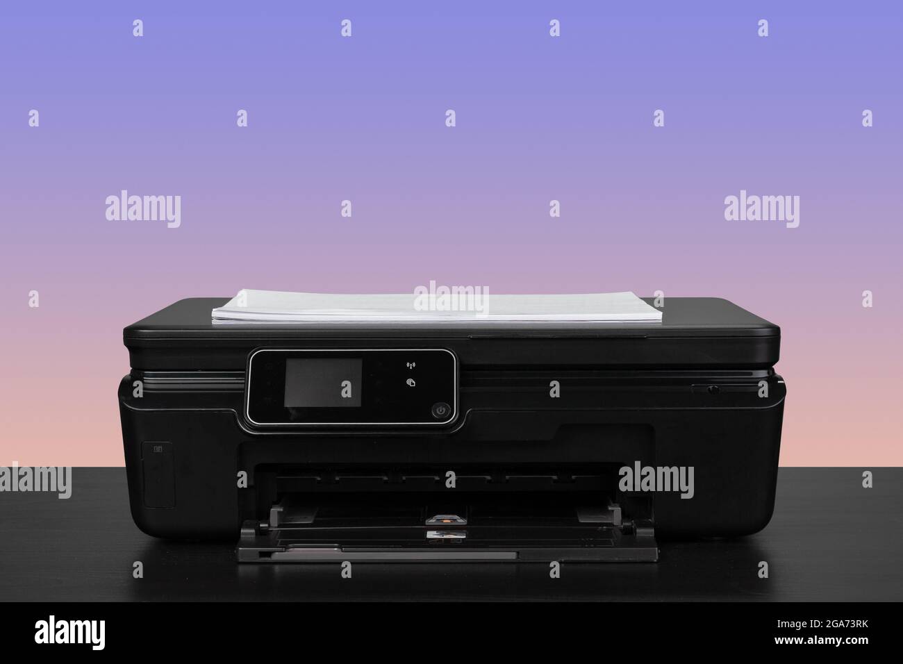 Home laser printer on desk against purple background Stock Photo - Alamy