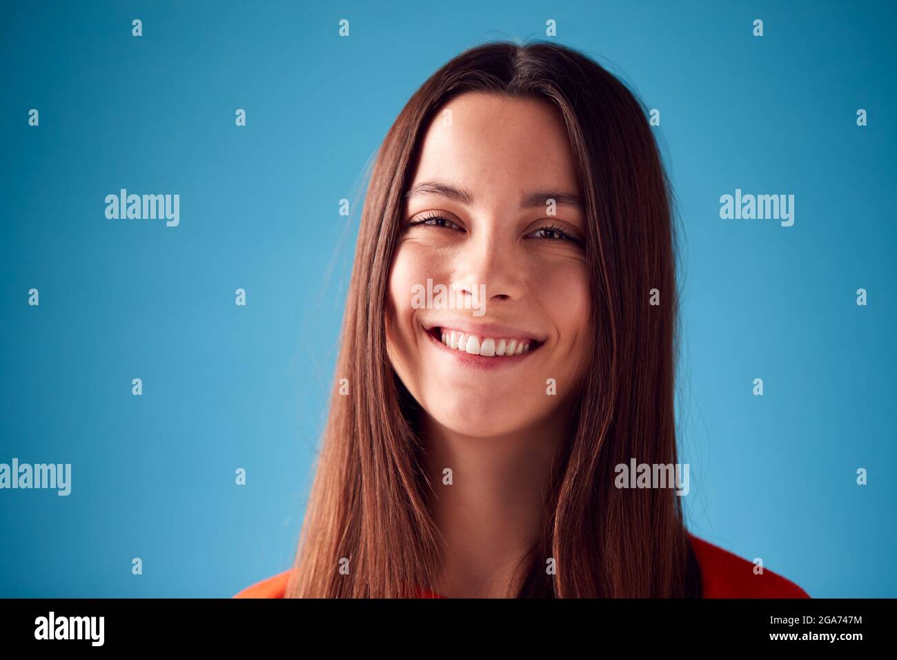 Studio Portrait Of Confident Young Woman Looking Into Camera Against ...