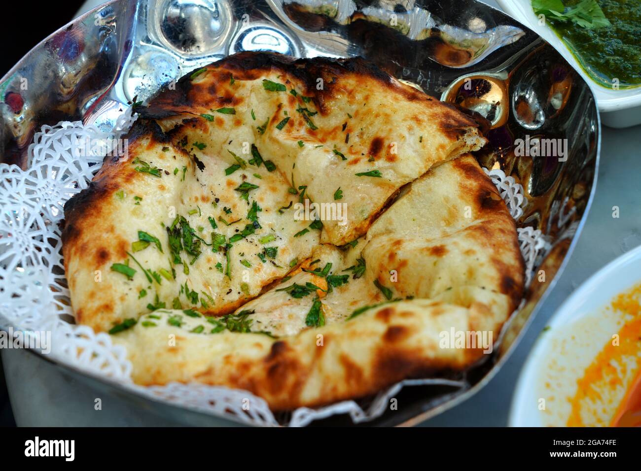 A basket of hot garlic naan bread at an Indian restaurant Stock Photo ...