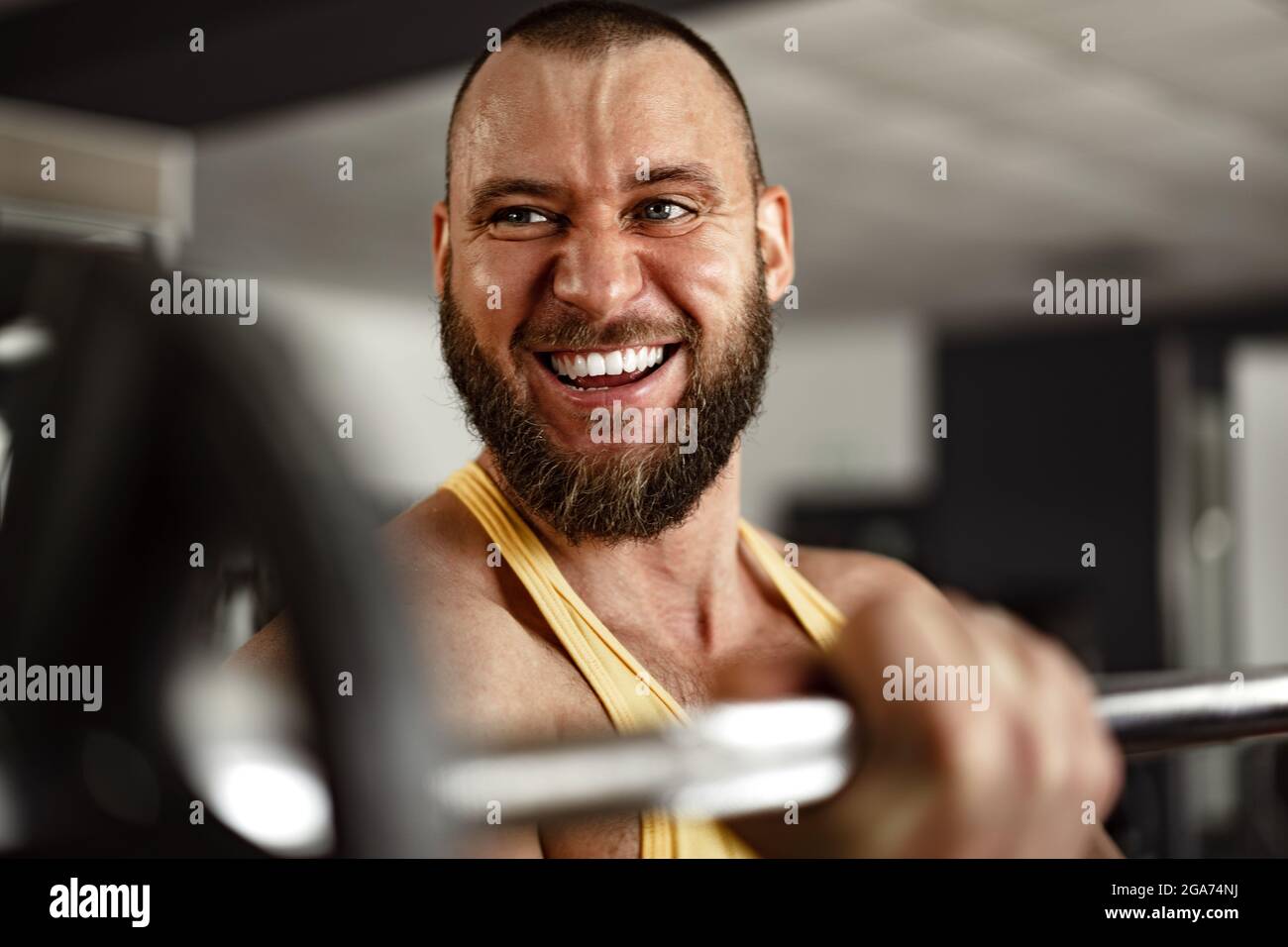 Cheerful smiling man bodybuilder standing in a gym Stock Photo - Alamy