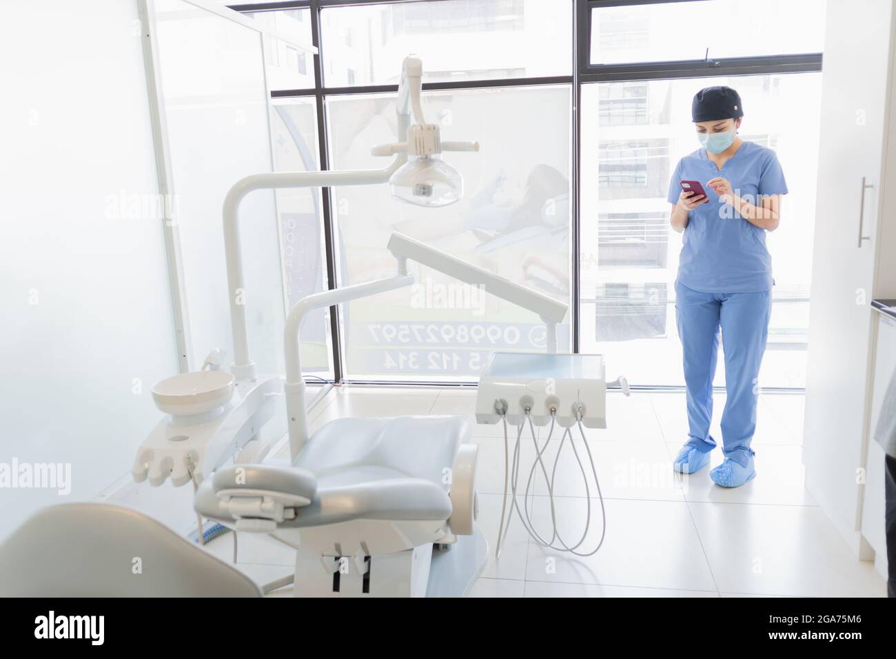 Dentist at her office checking the phone Stock Photo - Alamy