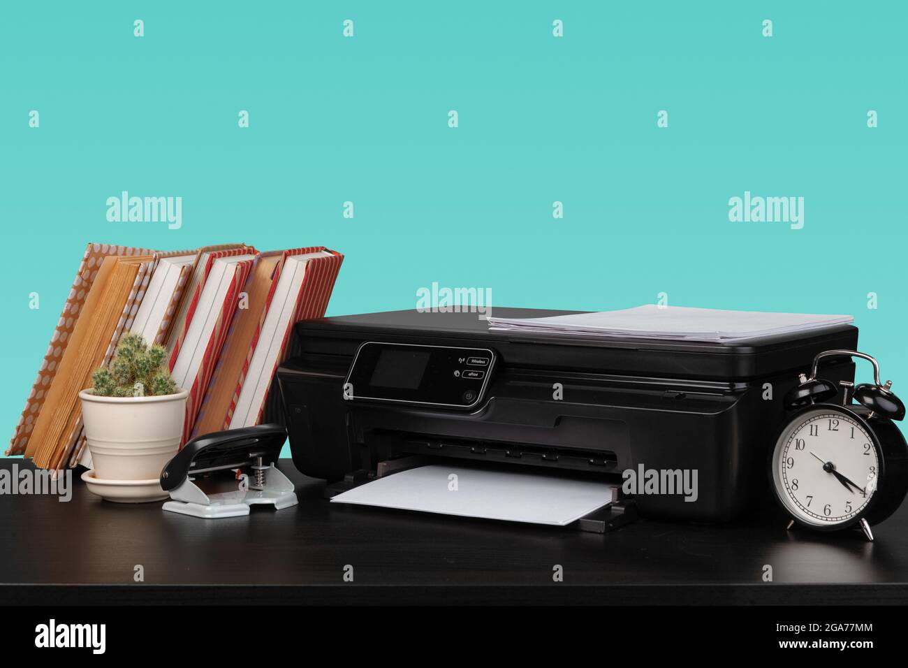 Home laser printer on desk against green background Stock Photo - Alamy