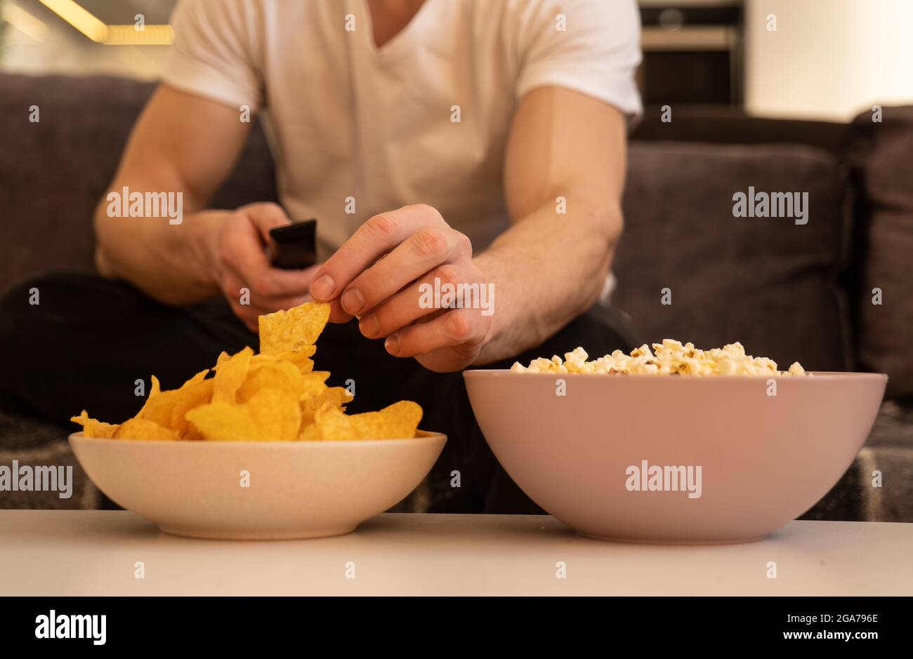 Close up of man's hand take chips from bowl Stock Photo - Alamy