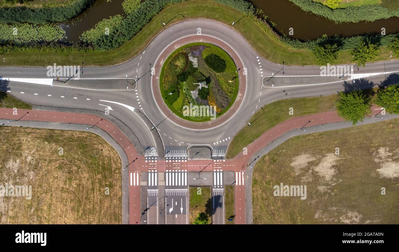 Top down aerial drone view of a small traffic roundabout on a quiet ...