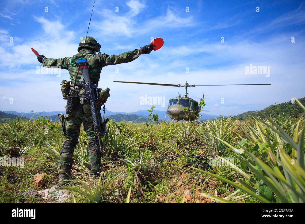 Soldier giving signal to helicopter to landing Stock Photo - Alamy