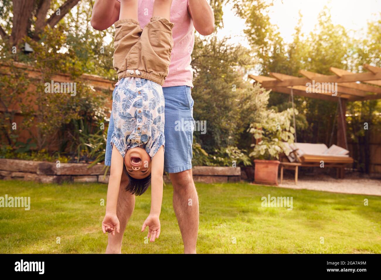 Holding him upside down hi-res stock photography and images - Alamy