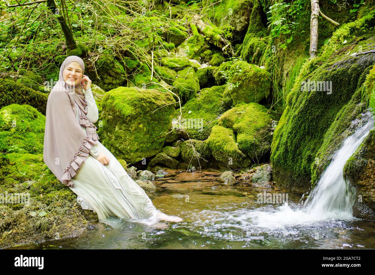 A young Muslim woman with hijab untouched nature, enjoys the natural ...