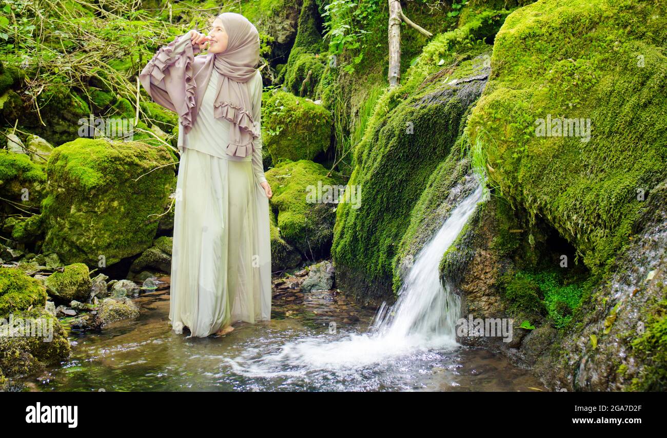A young Muslim woman with hijab untouched nature, enjoys the natural ...