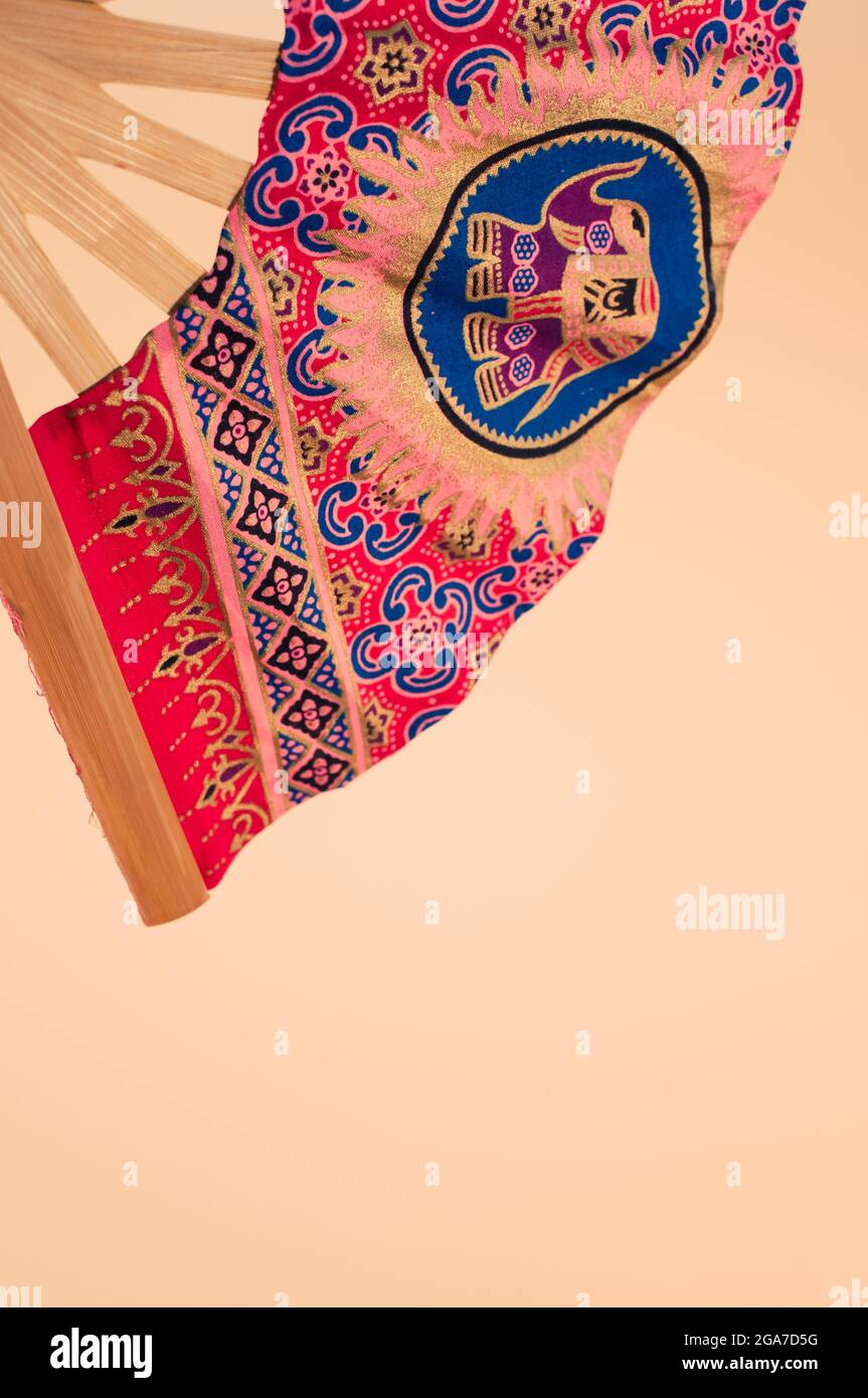Red hand fan isolated on a beige background with free space for text ...