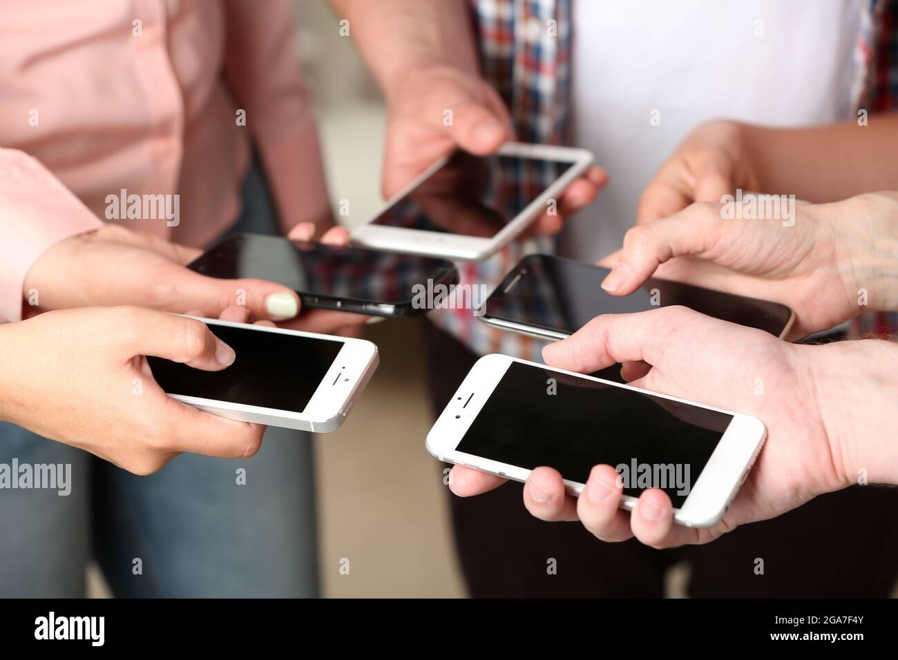 Many hands holding mobile phones close up Stock Photo - Alamy