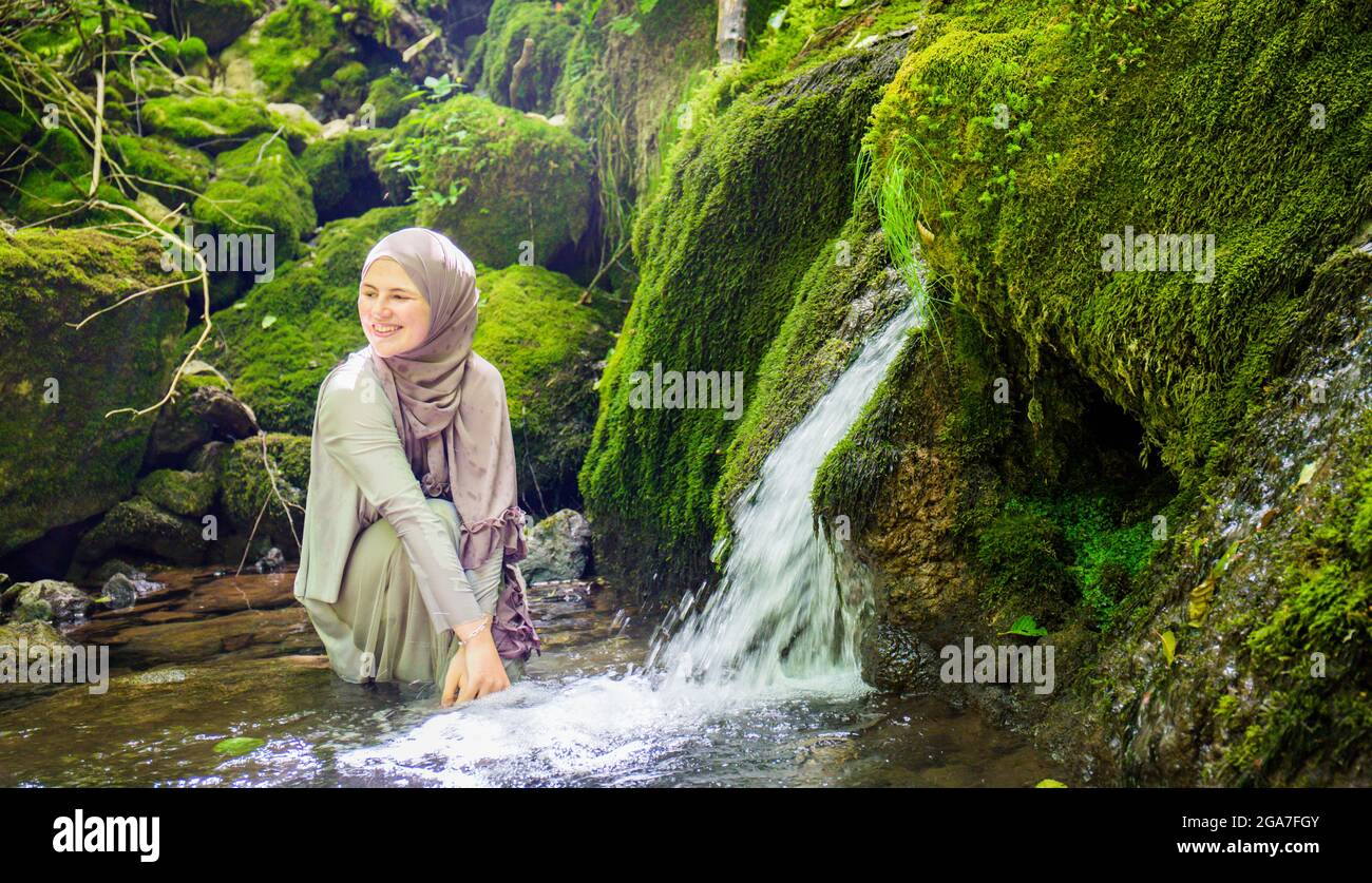 A young Muslim woman with hijab untouched nature, enjoys the natural ...