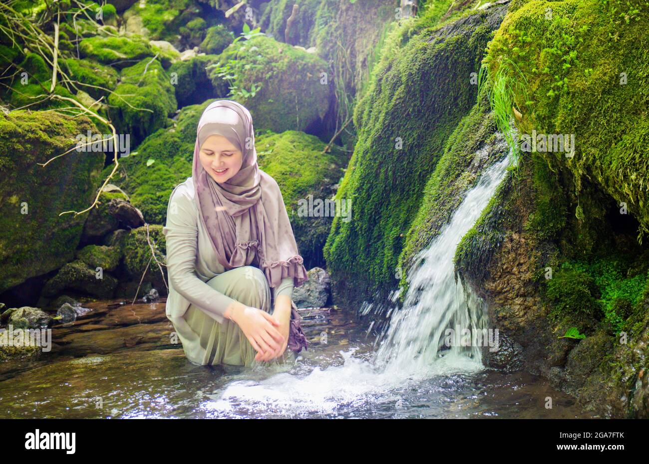 A young Muslim woman with hijab untouched nature, enjoys the natural ...