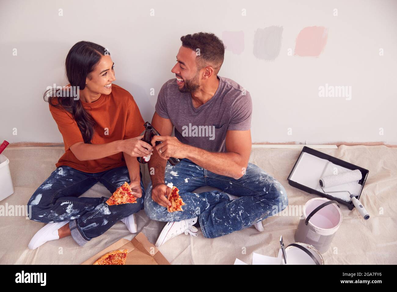 Couple Taking A Break And Drinking Beer And Eating Pizza As They ...