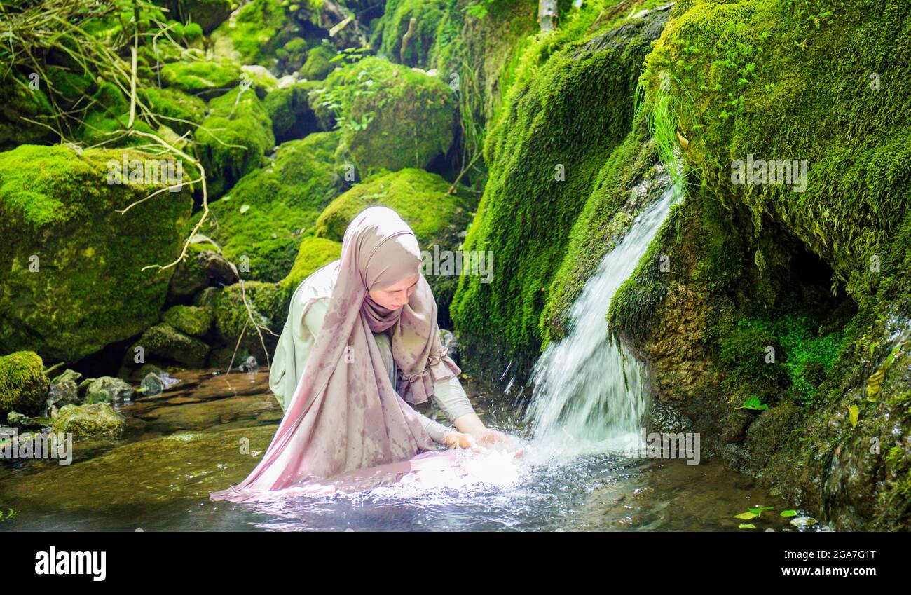 A young Muslim woman with hijab untouched nature, enjoys the natural ...