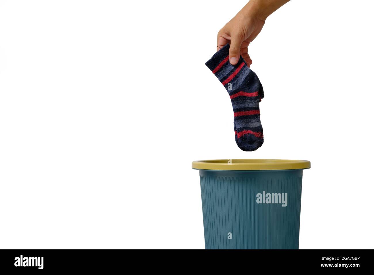 Man hand throws an old sock into trash on white background of isolate ...