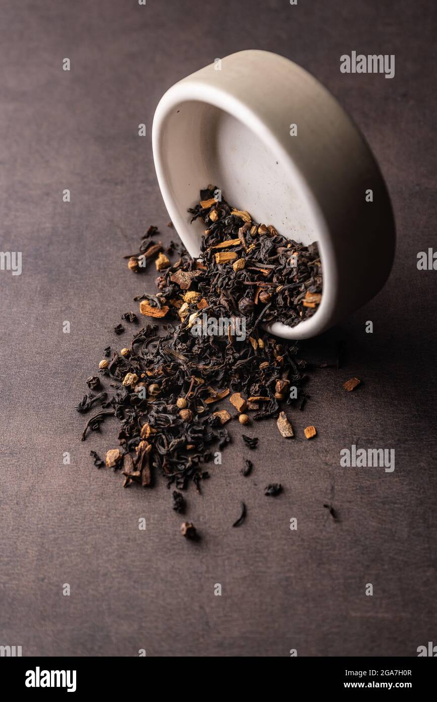 natural black leaf tea. brewing in a clay bowl. vertical angle, macro ...