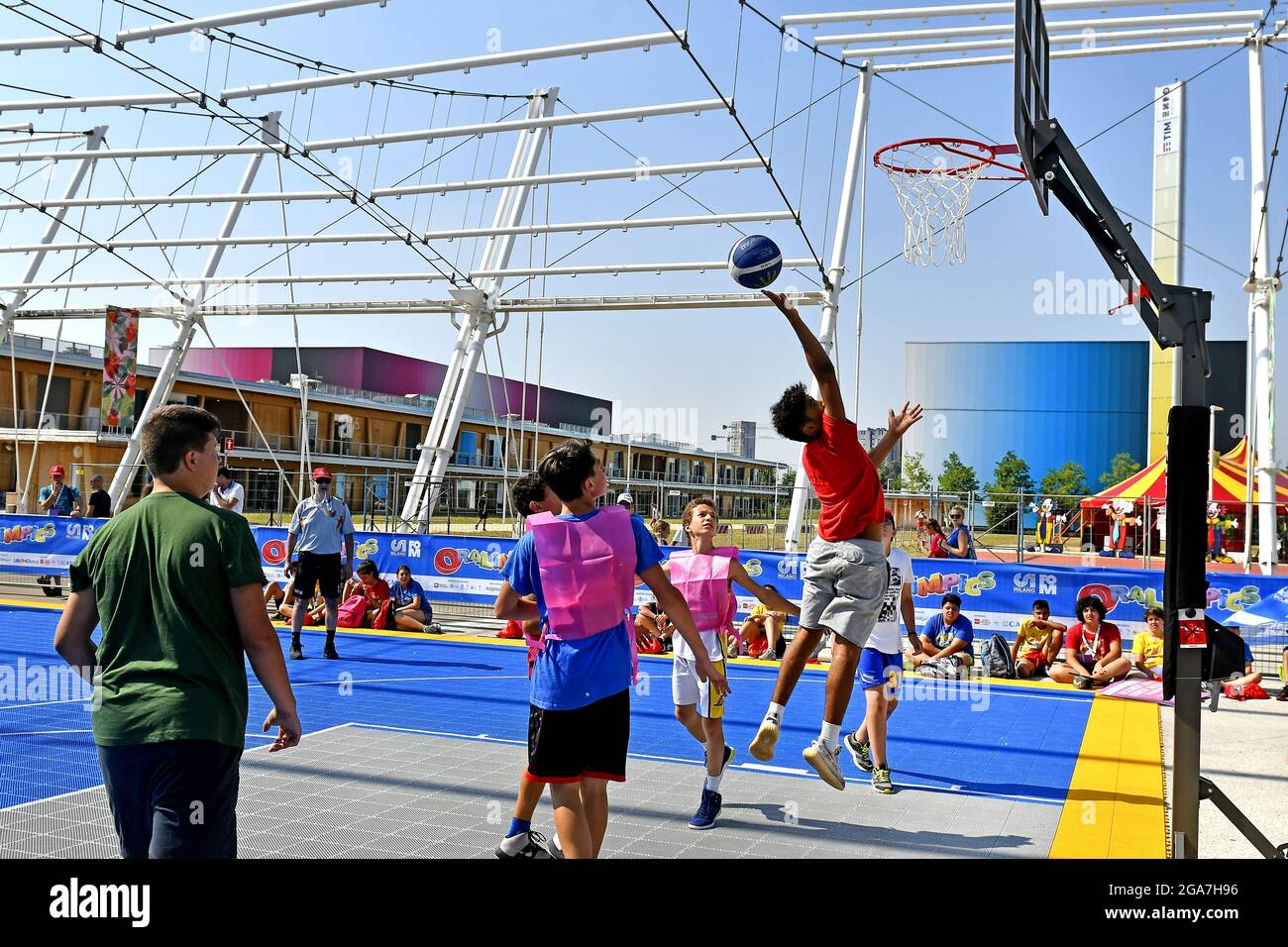 Boys playing on an outdoor basketball court, during a summer camp in ...