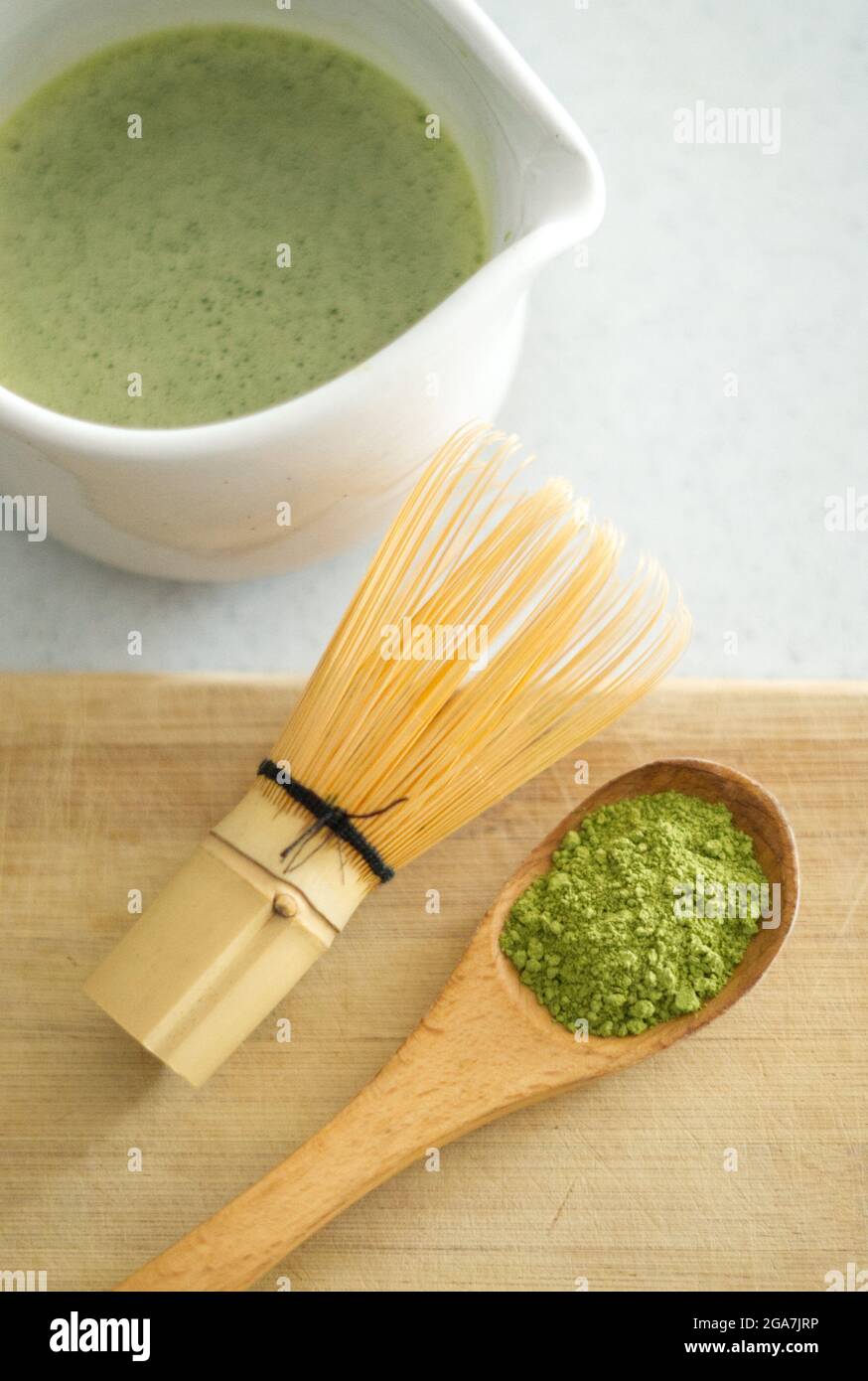 Mixing green Japanese matcha powder in a white ceramic chawan with ...