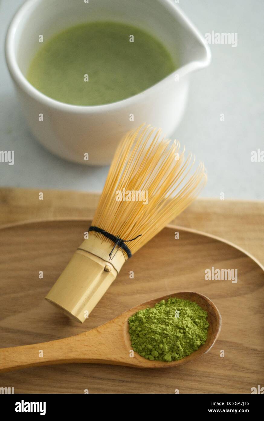 Mixing green Japanese matcha powder in a white ceramic chawan with ...
