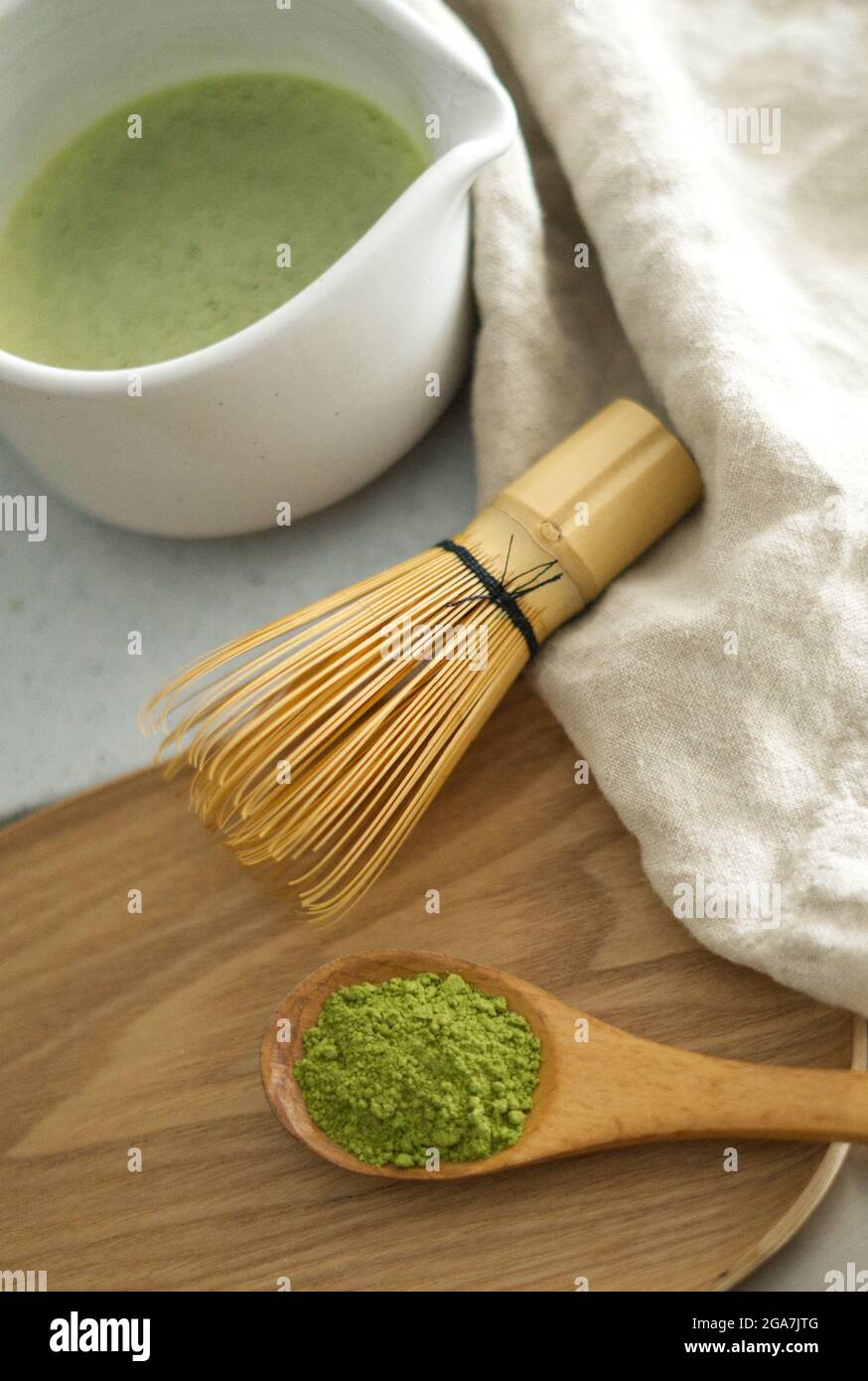 Mixing green Japanese matcha powder in a white ceramic chawan with ...