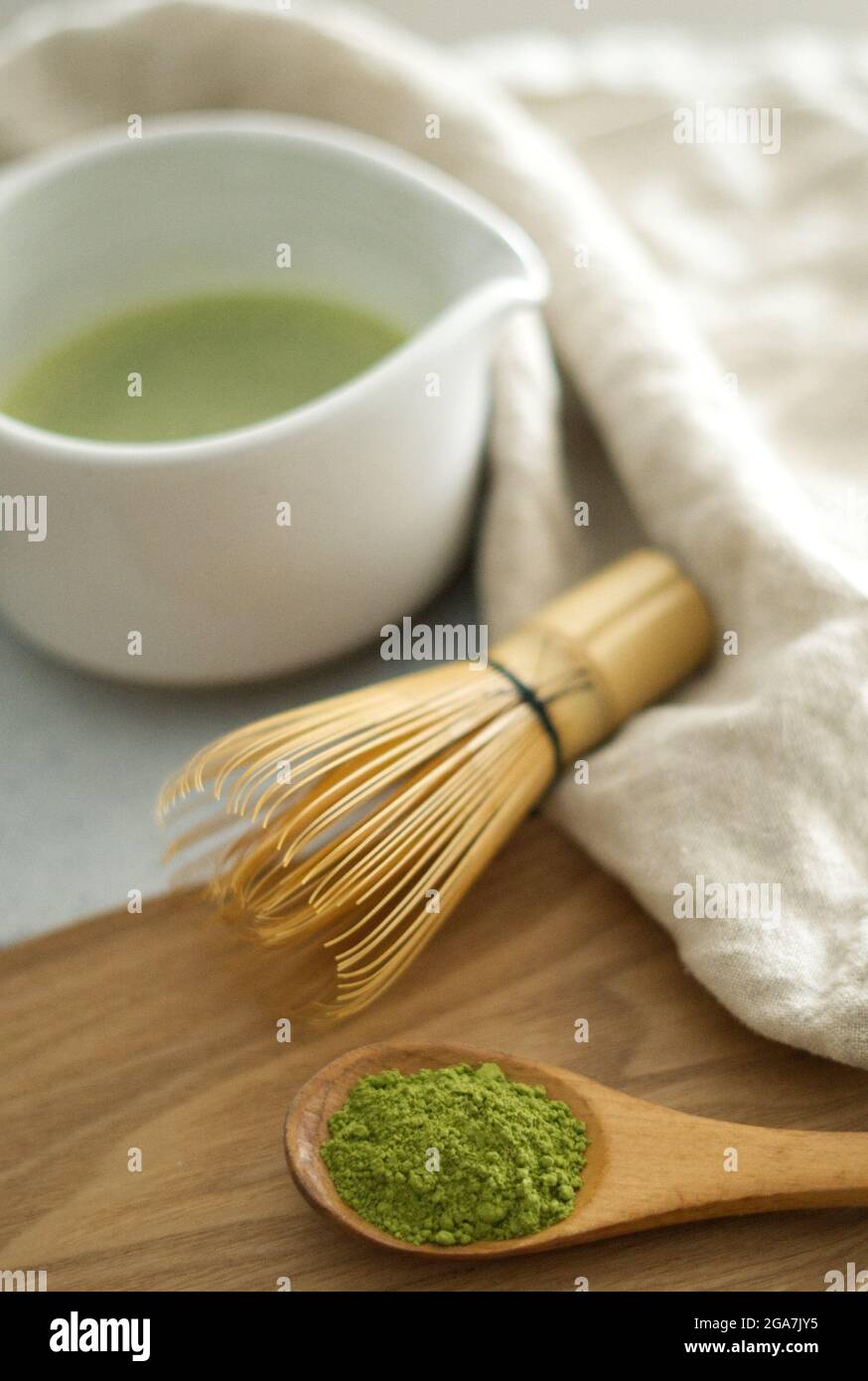 Mixing green Japanese matcha powder in a white ceramic chawan with ...
