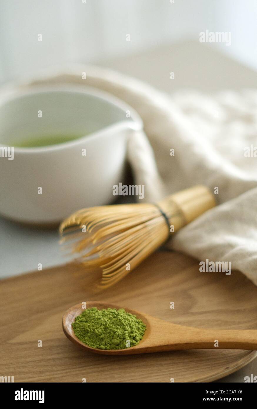 Mixing green Japanese matcha powder in a white ceramic chawan with ...