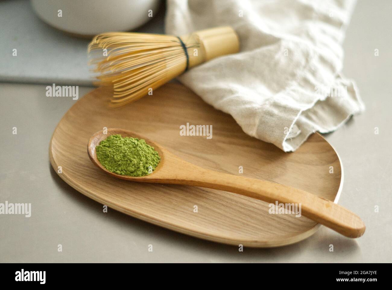 Mixing green Japanese matcha powder in a white ceramic chawan with ...