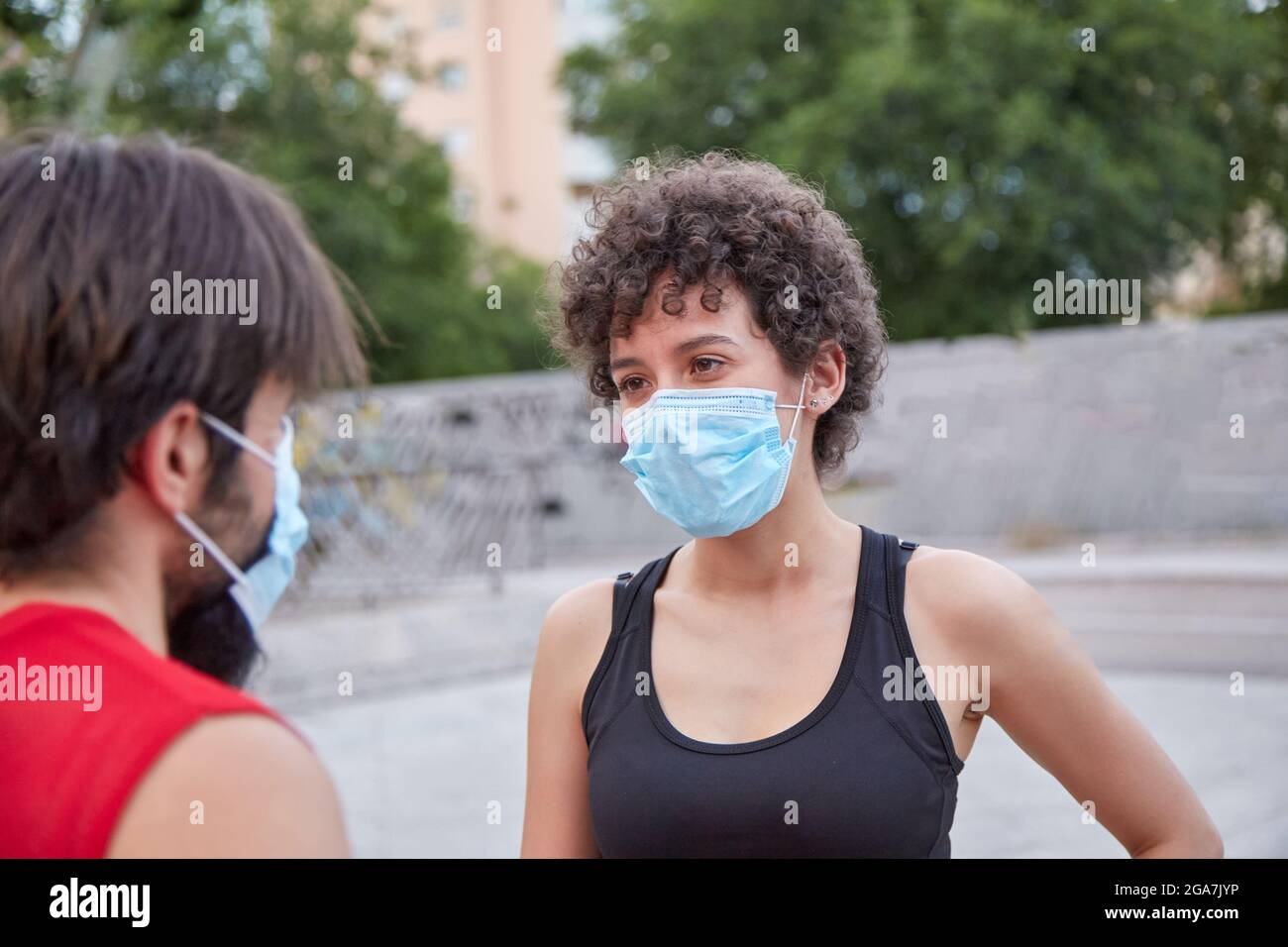 Two people having a conversation protected by face masks Stock Photo ...