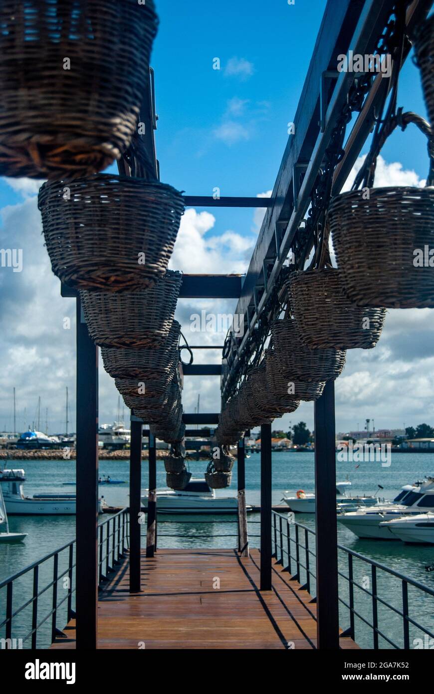 Fishing boats seen from the wooden pier that is decorated with hanging ...