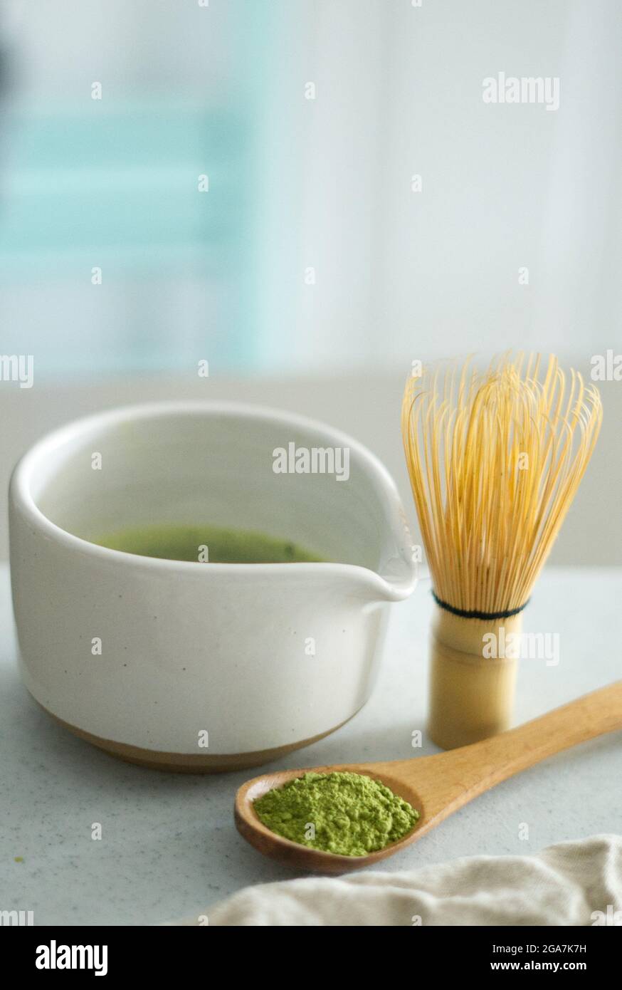 Mixing green Japanese matcha powder in a white ceramic chawan with ...