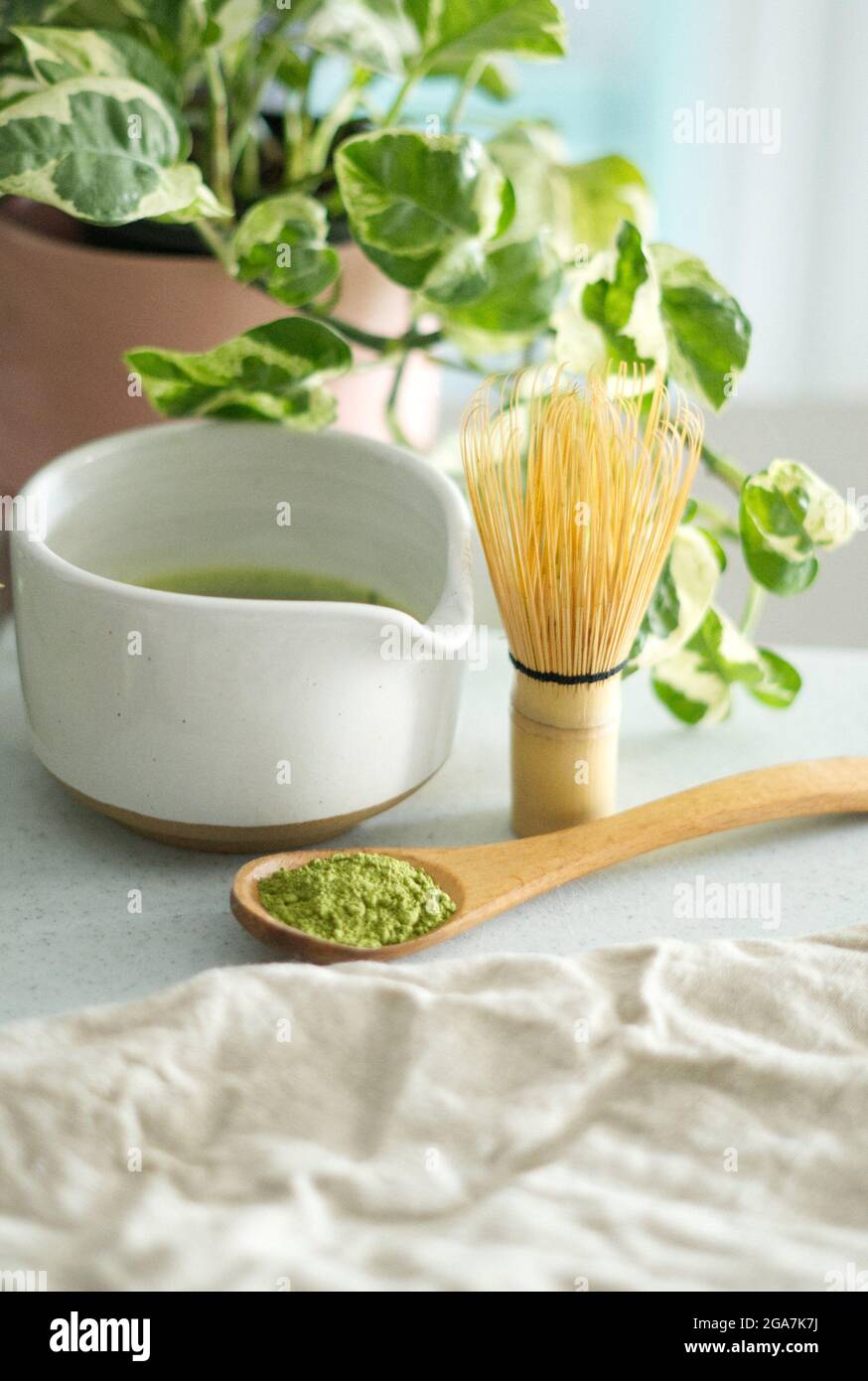 Mixing green Japanese matcha powder in a white ceramic chawan with ...