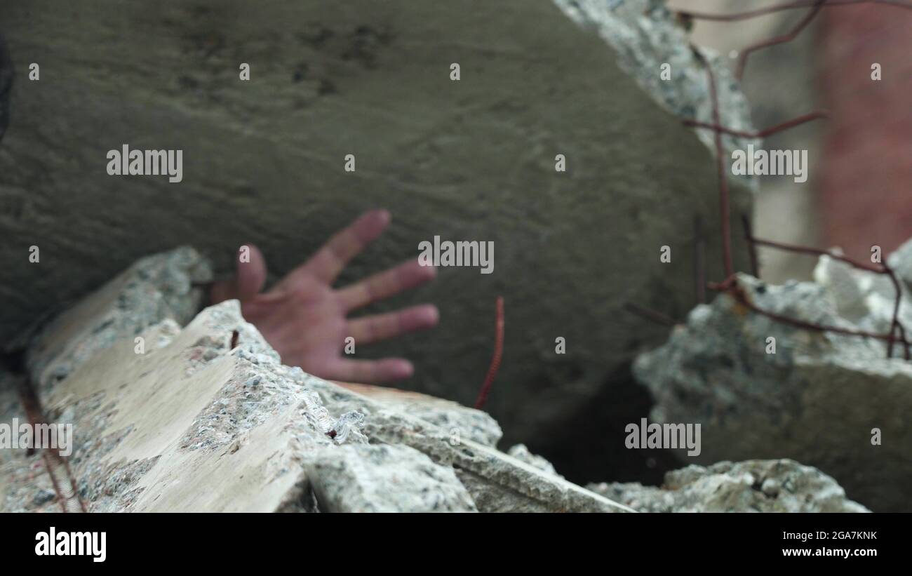 Hand of a man who crashed a house. Pressed by a reinforced concrete ...
