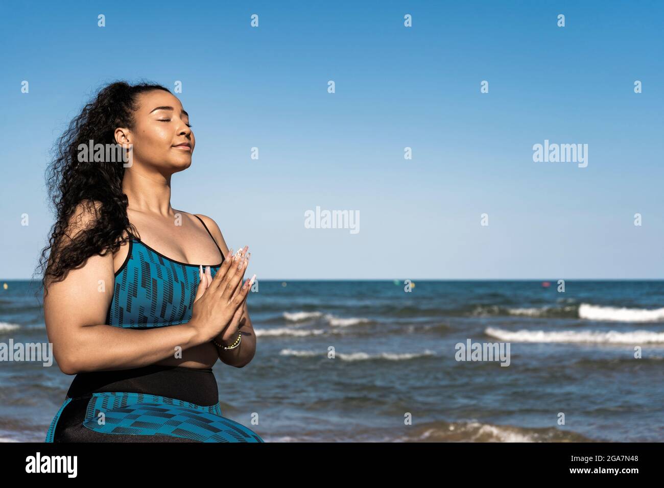 Beautiful woman practicing yoga ,tree pose with namaste on beach Stock ...