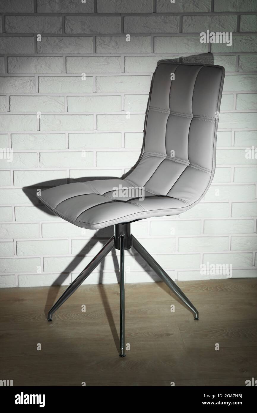 Modern chair on brick wall background Stock Photo - Alamy