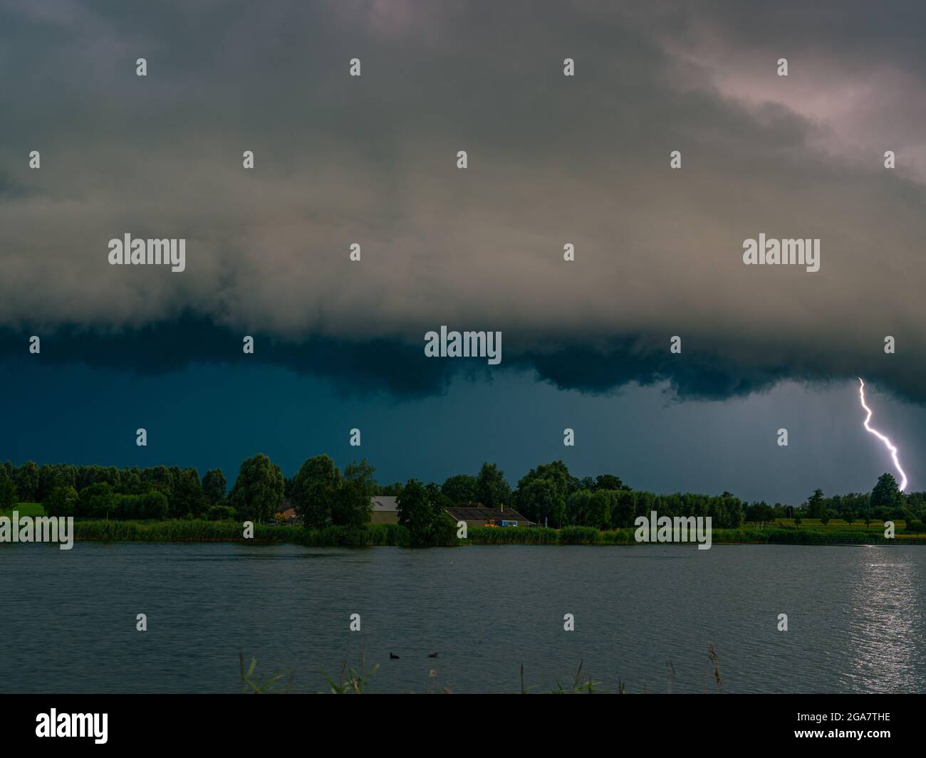 Lightning bolt shoots down from the clouds of a strong squall line ...
