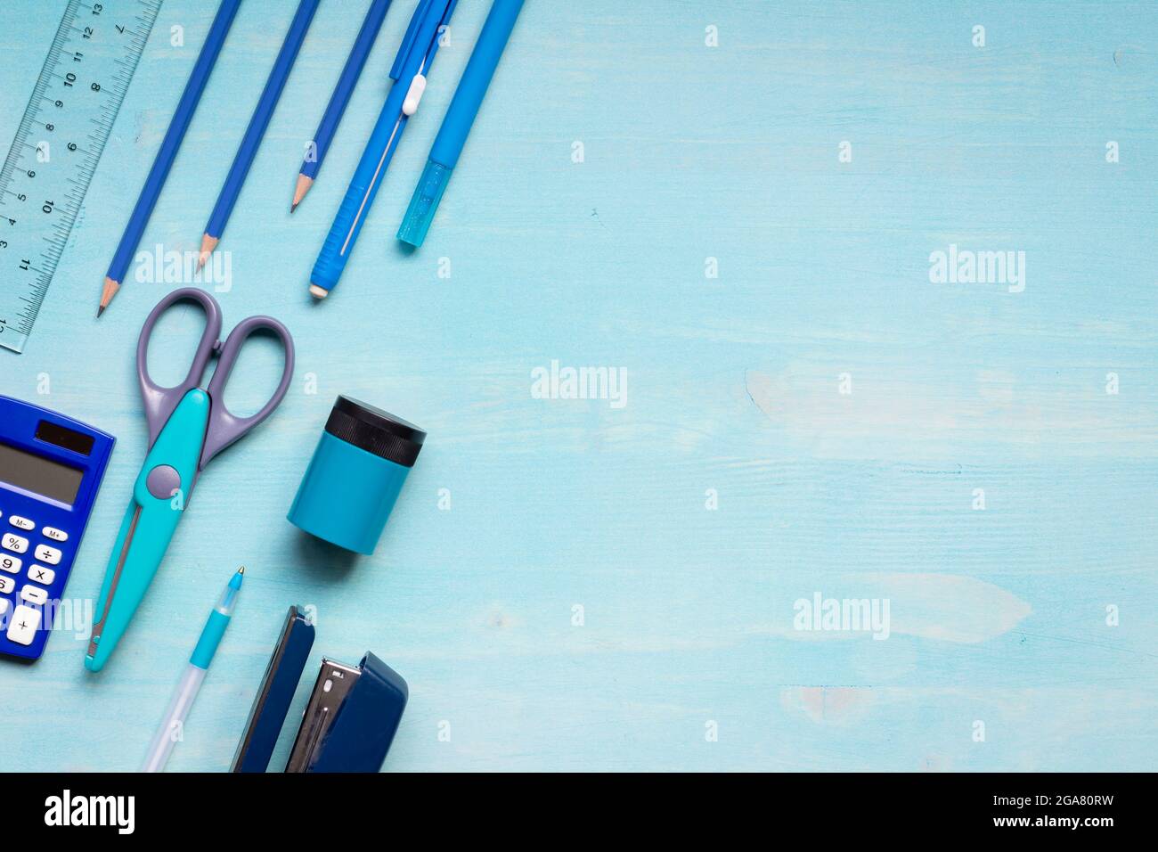 blue and grey school supplies knolling on blue wood background with ...