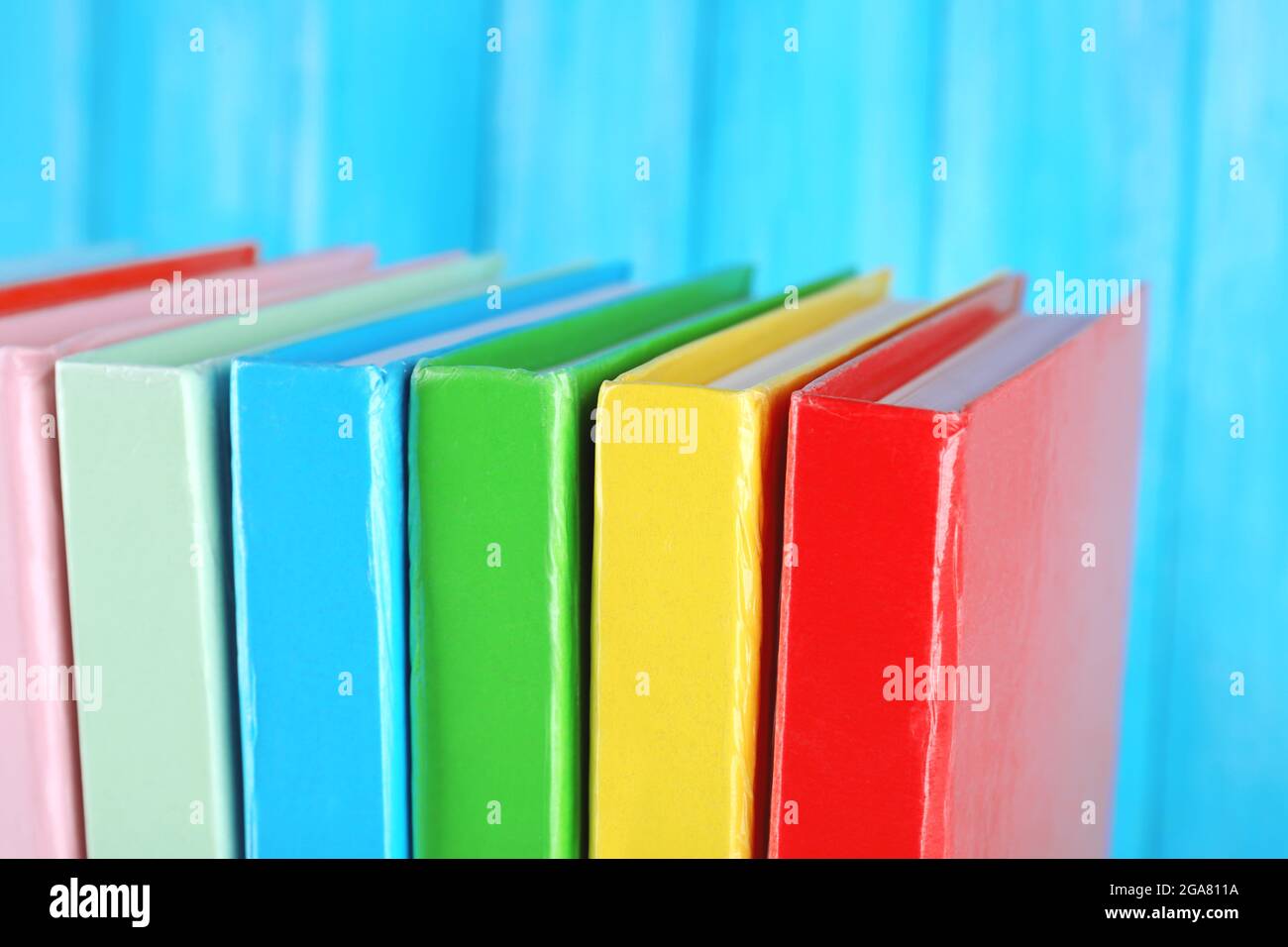 Colorful books on turquoise wooden background Stock Photo - Alamy