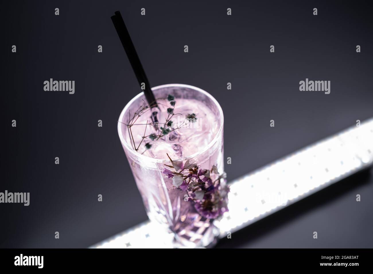 luxury violet fizz cocktail drink with flower decoration on black ...