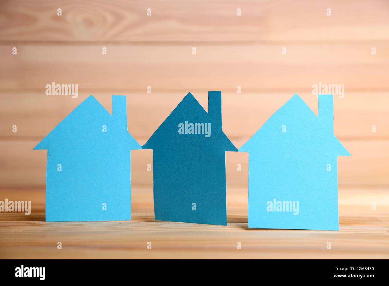 Paper houses on wooden background Stock Photo - Alamy