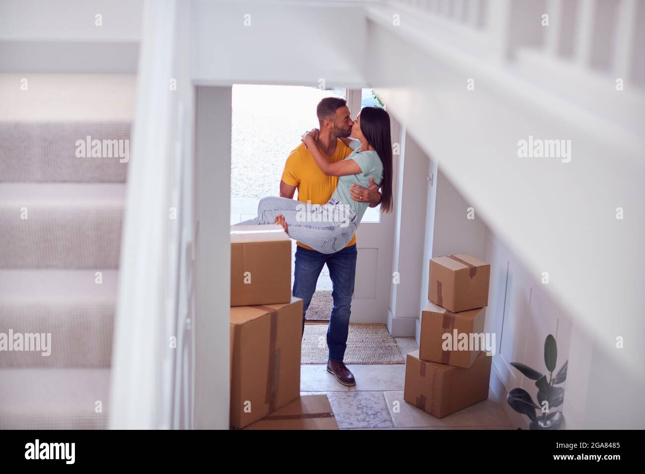 Man Carrying Woman Over Threshold Of New Home As Couple Move In ...