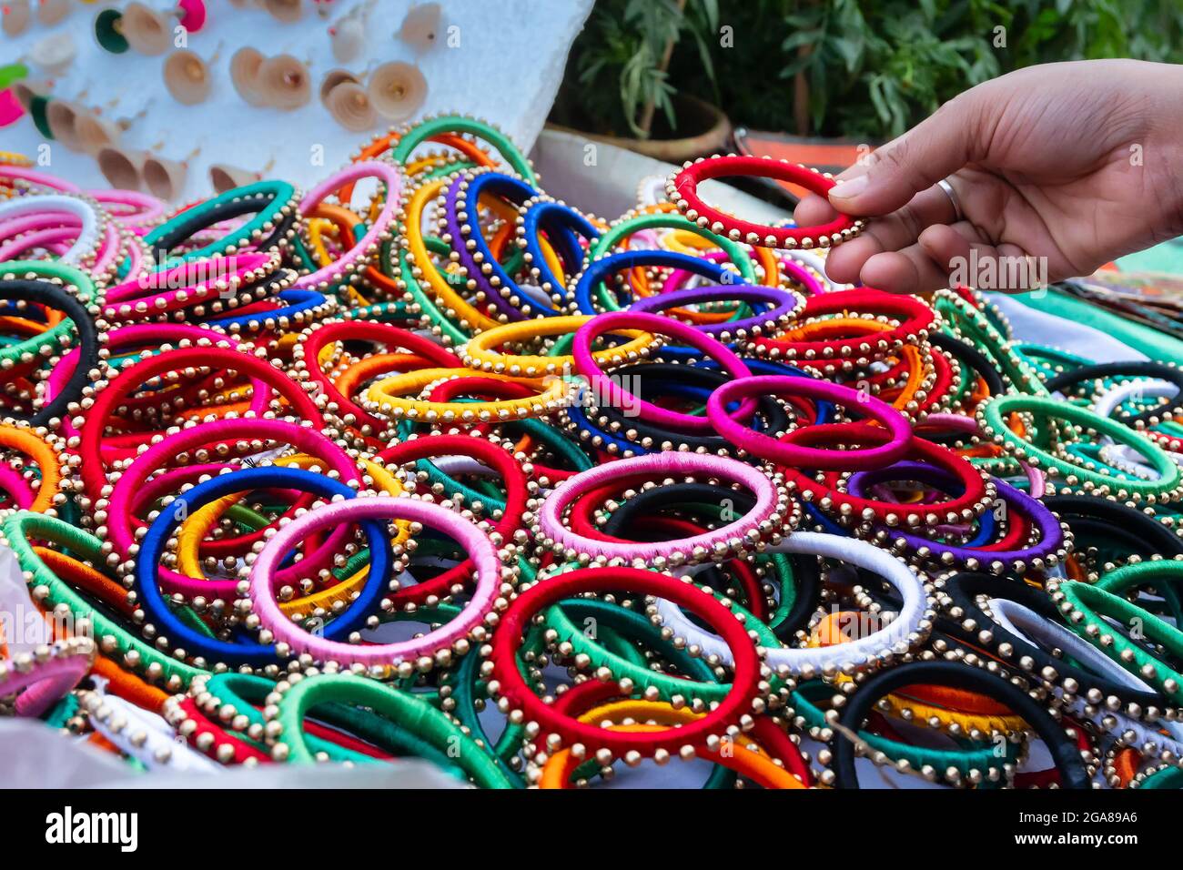 Woman checking colorful Indian bangles, handicrafts, on display during ...