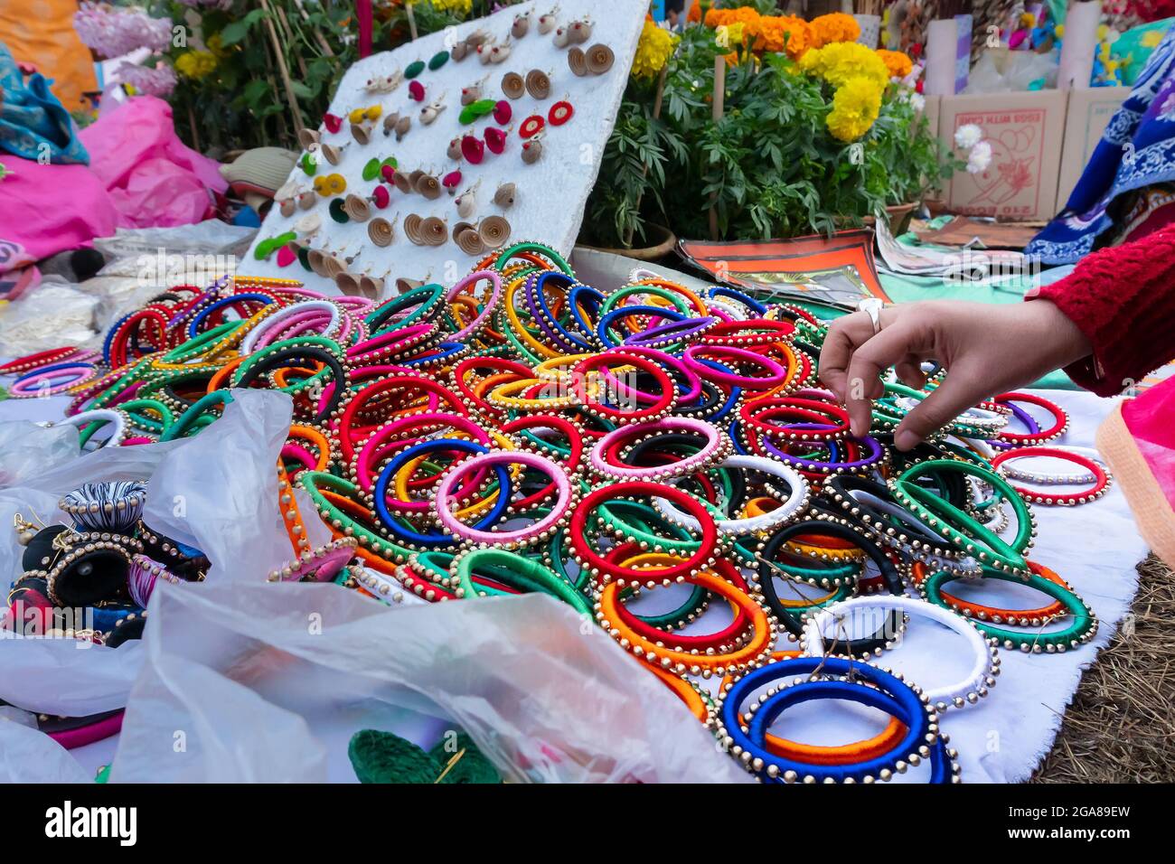 Woman checking colorful Indian bangles, handicrafts, on display during ...