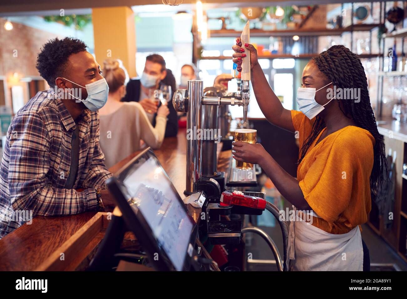 Female Bartender Wearing Face Mask Serving Male Customer With Beer ...