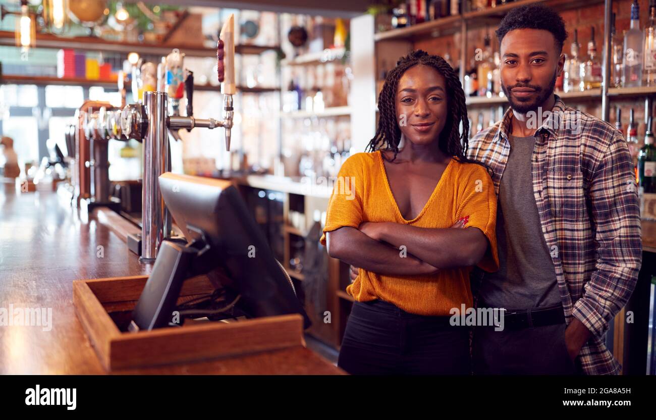 Portrait Of Smiling Couple Owning Bar Standing Behind Counter Stock ...